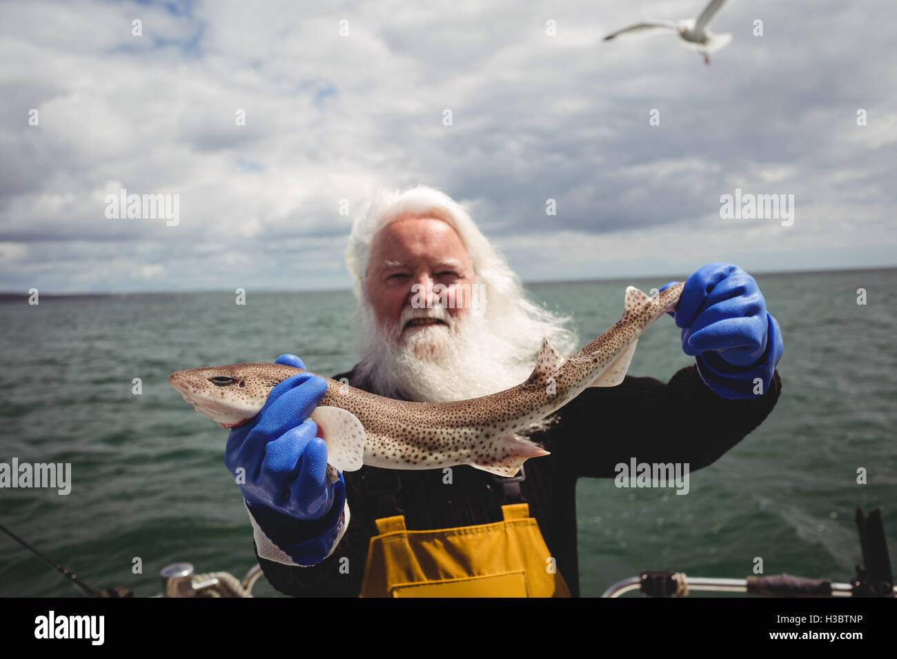Portrait of fisherman holding fish Stock Photo - Alamy