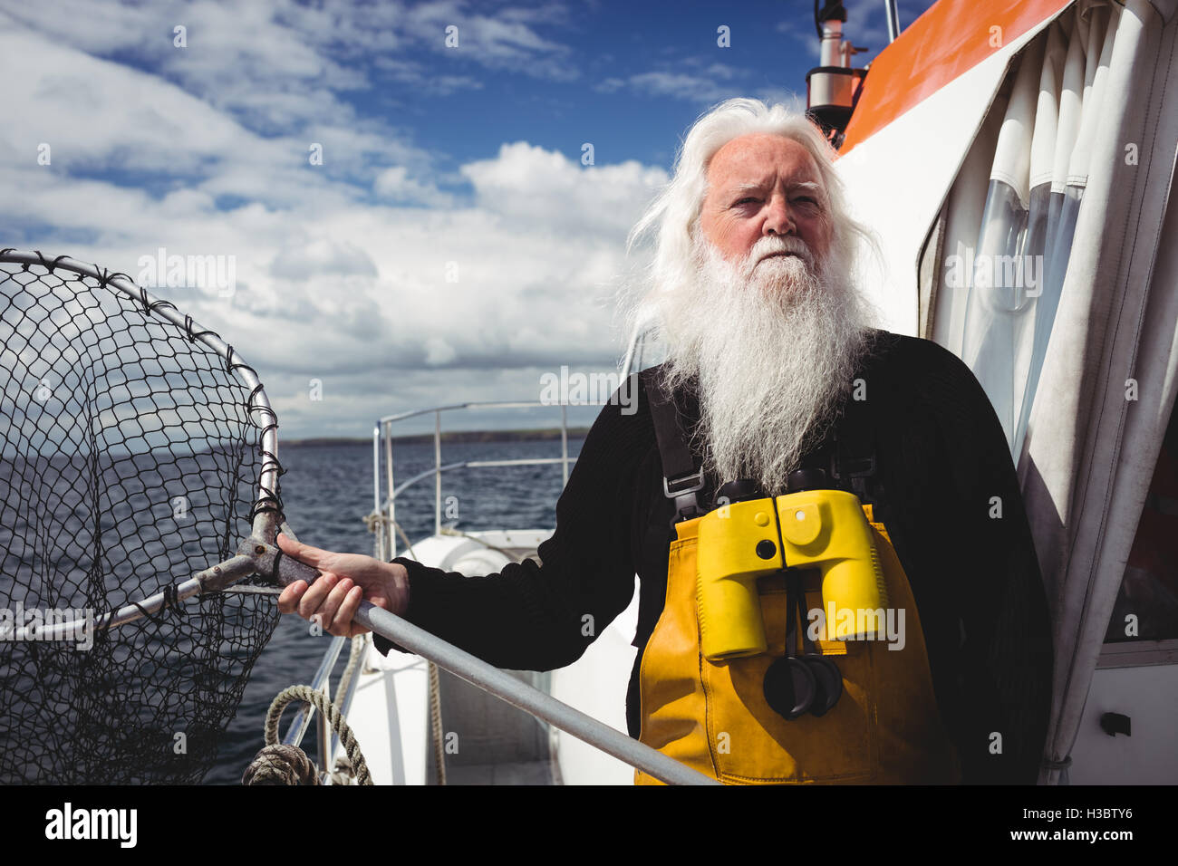 Fisherman holding fishing net Stock Photo - Alamy