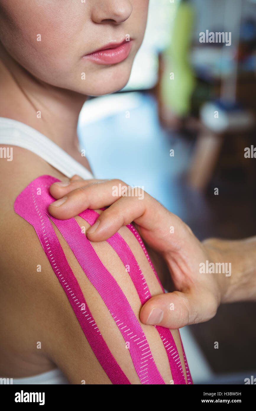 Male therapist sticking tape on female patient Stock Photo - Alamy