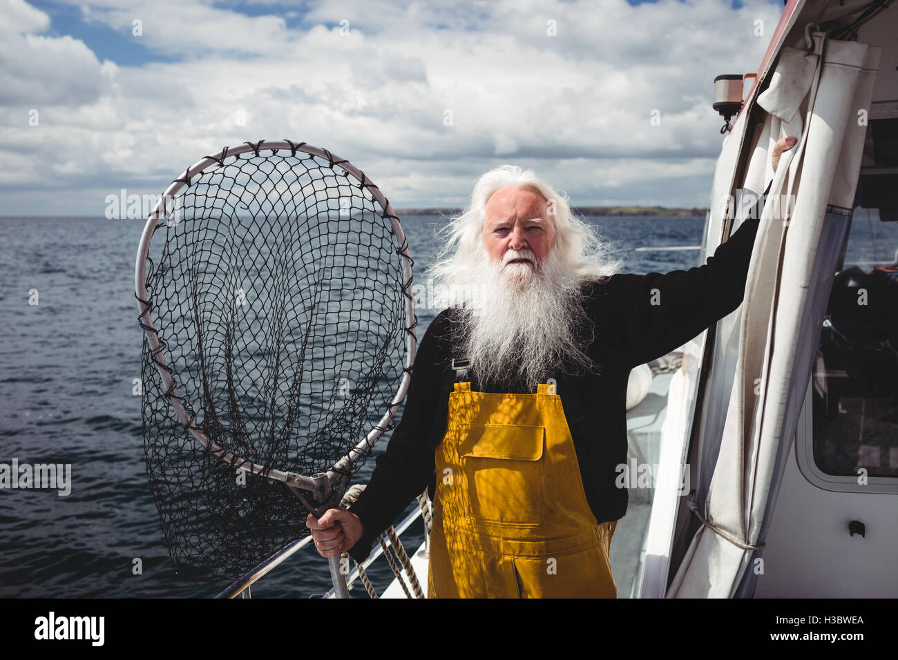 Portrait of fisherman holding fishing net Stock Photo - Alamy