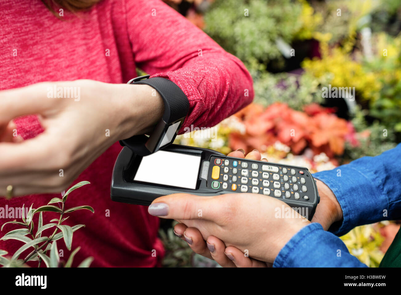 Woman making payment through smart watch Stock Photo - Alamy