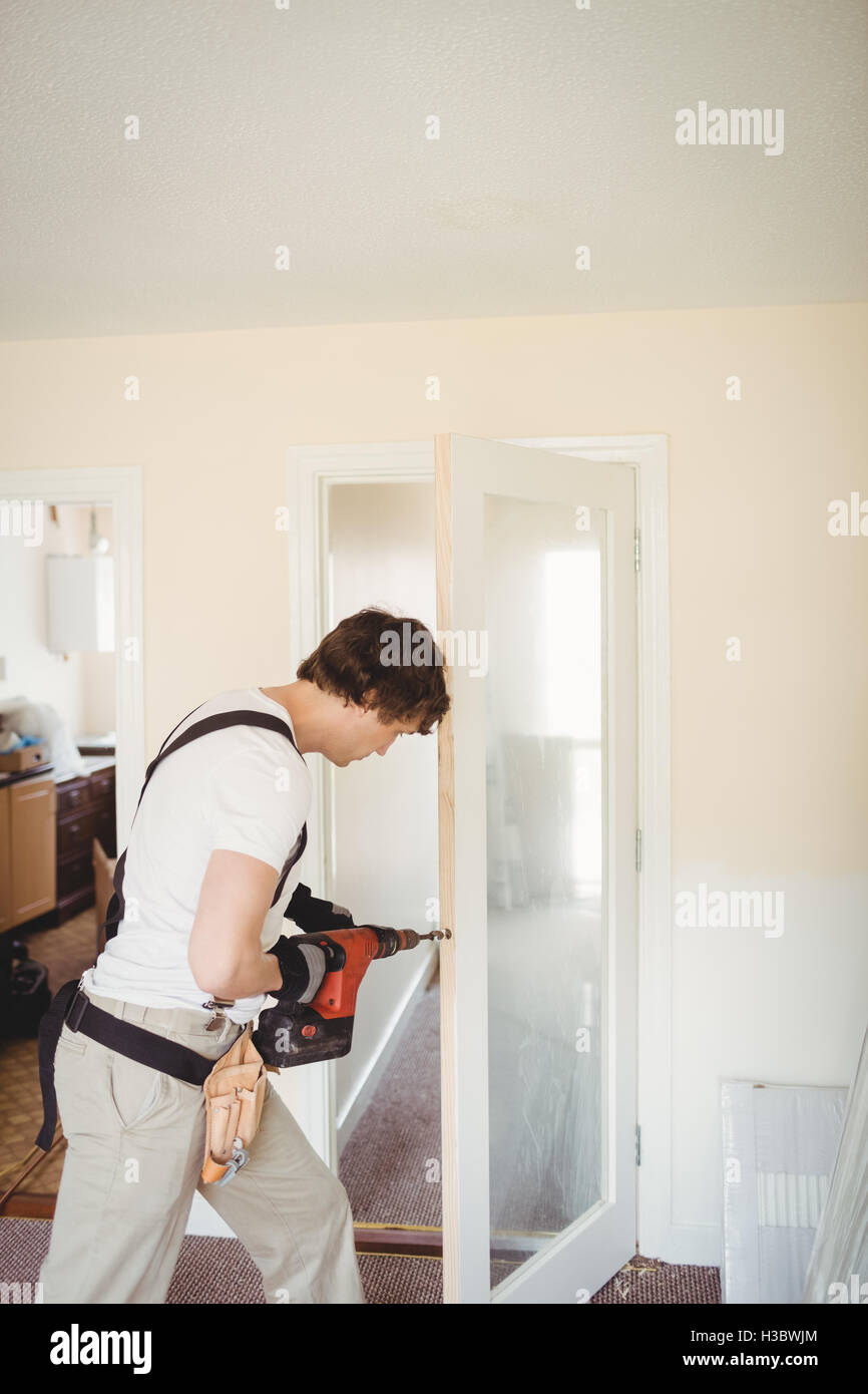 Carpenter drilling wooden door with drilling machine Stock Photo - Alamy