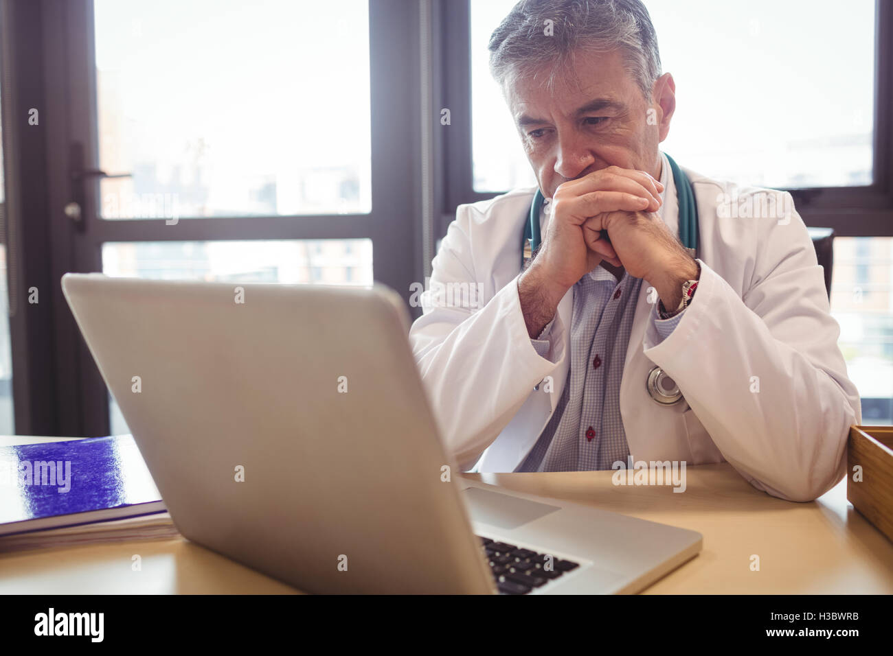 Doctor using laptop at his desk Stock Photo - Alamy