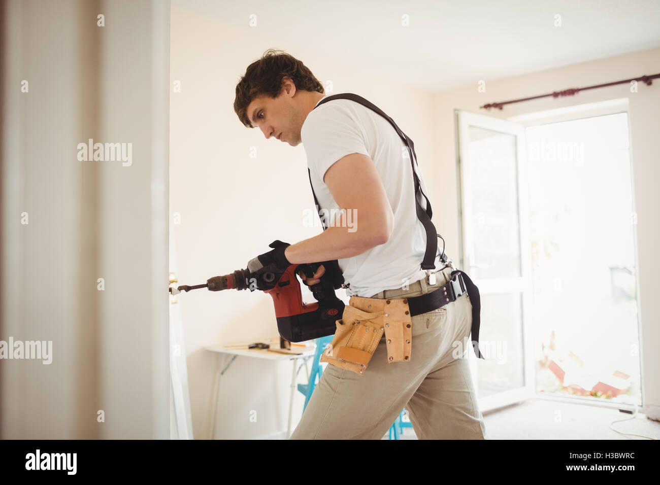 Carpenter drilling wooden door with drilling machine Stock Photo - Alamy
