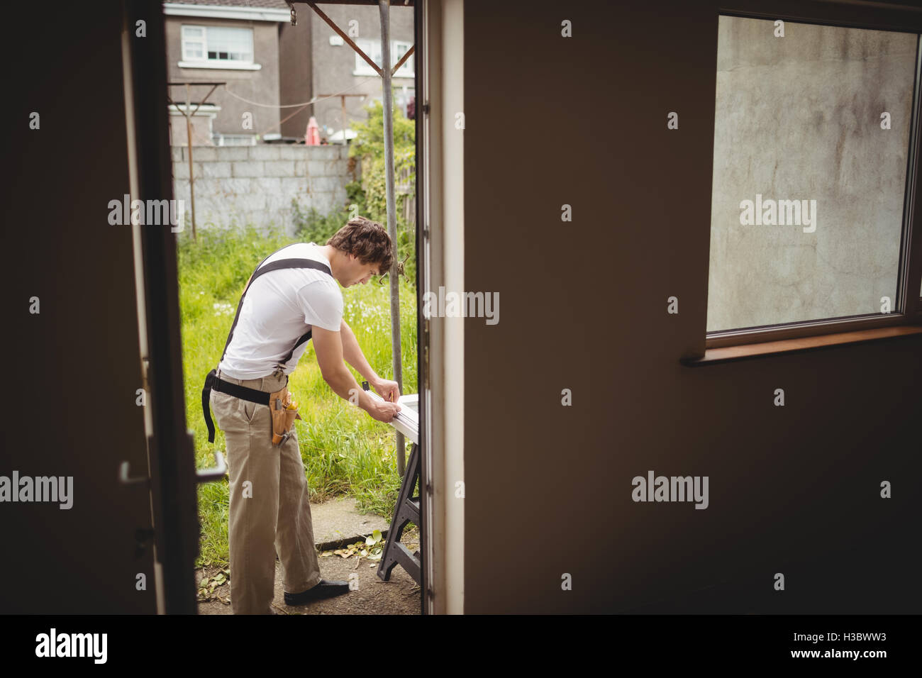 Carpenter measuring a door frame Stock Photo - Alamy