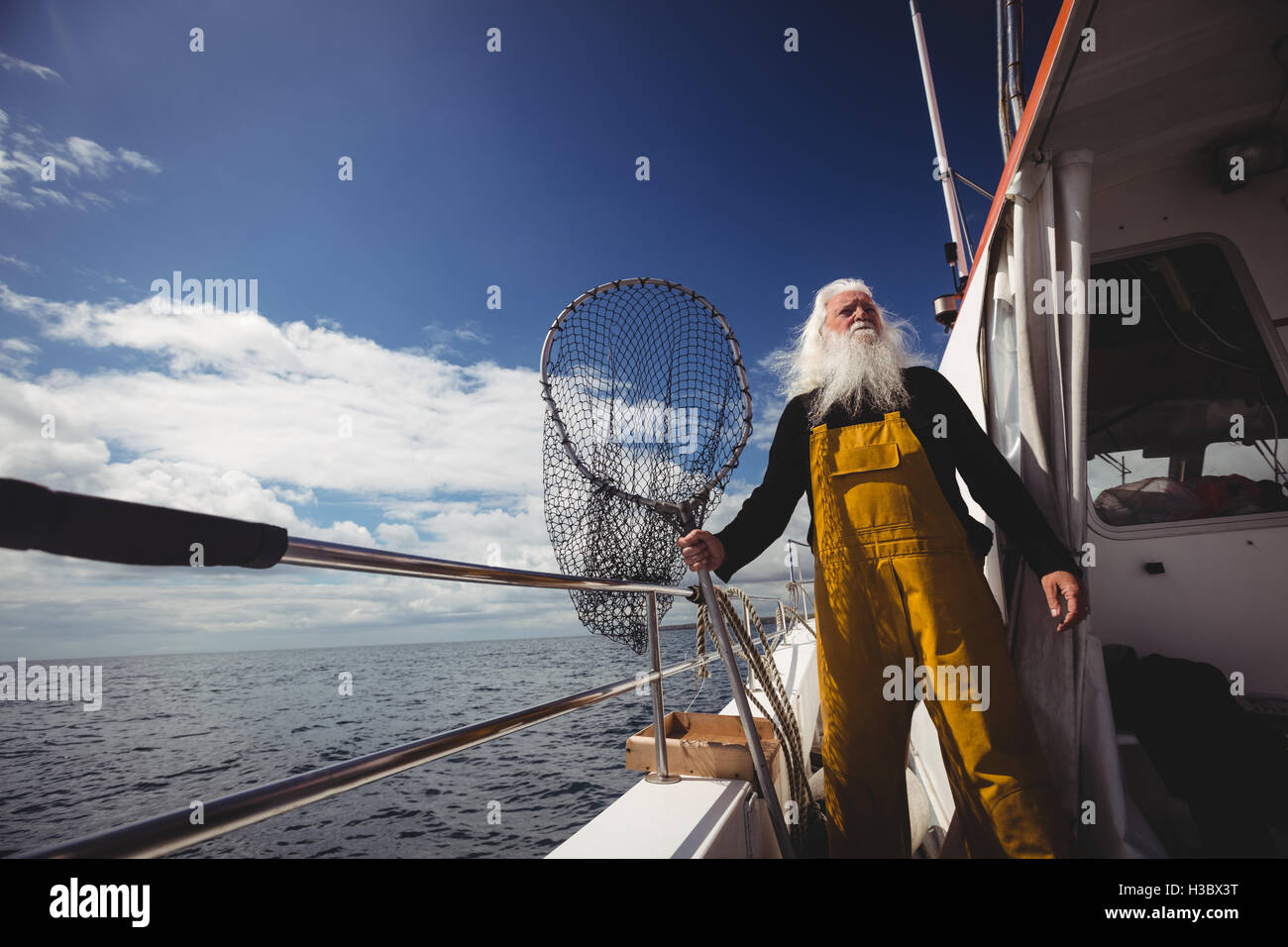 Fisherman holding fishing net Stock Photo - Alamy