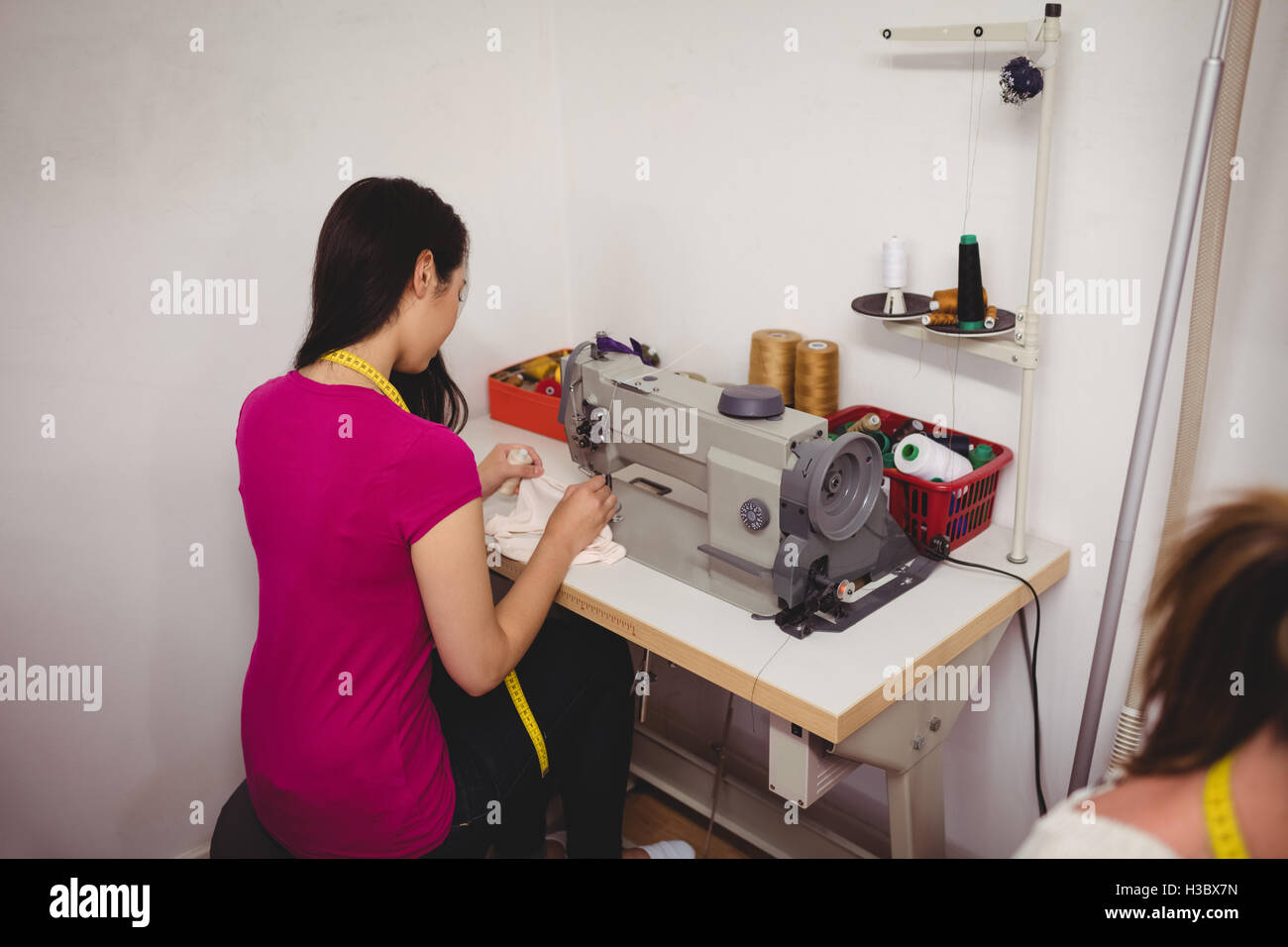 Female dressmaker sewing in the studio Stock Photo - Alamy