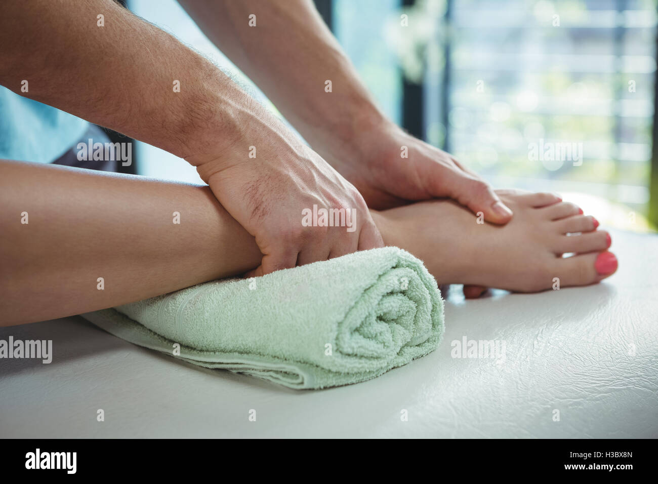 Physiotherapist giving physical therapy to the leg of a female patient ...
