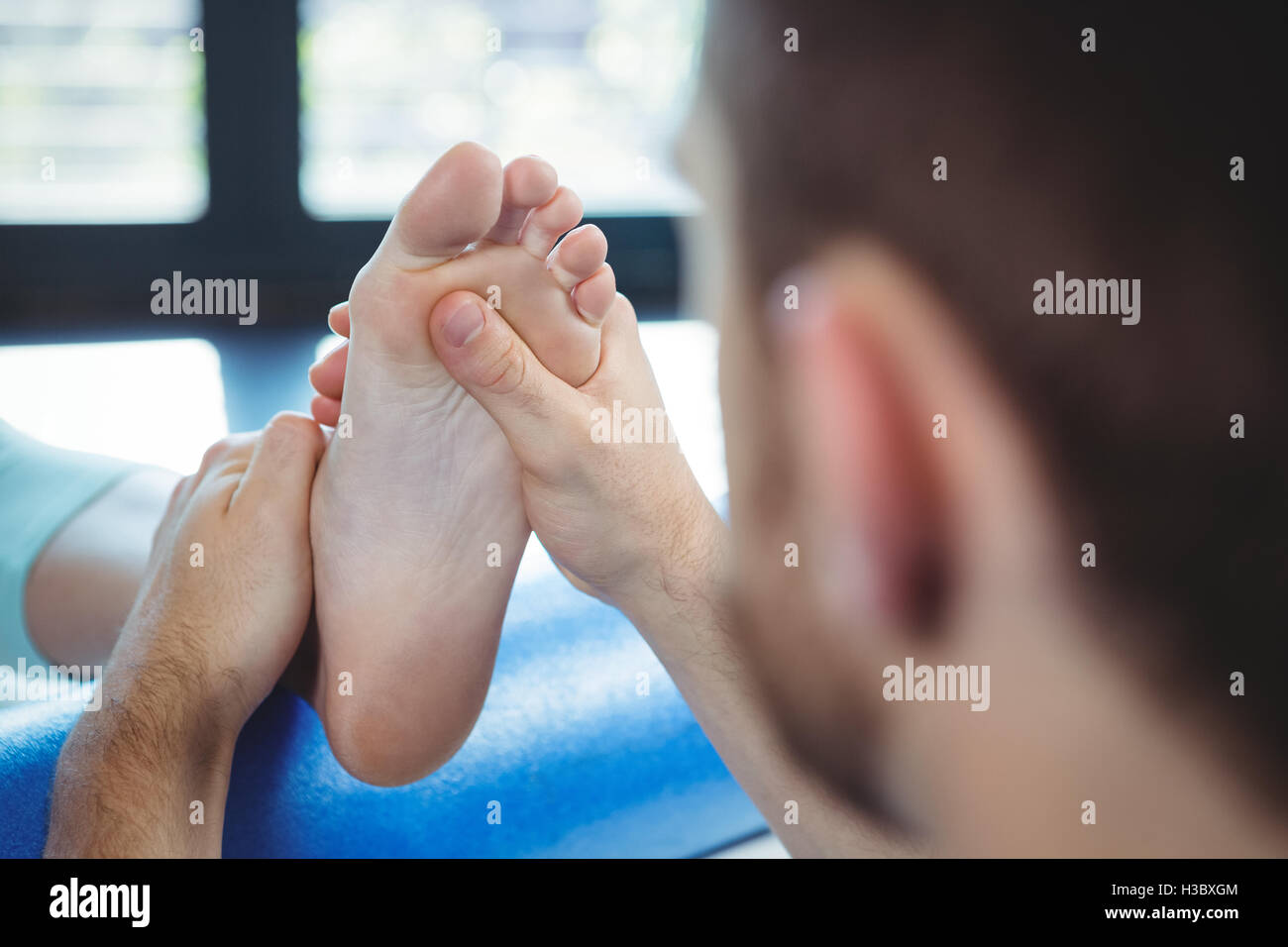 Male physiotherapist giving foot massage to female patient Stock Photo ...