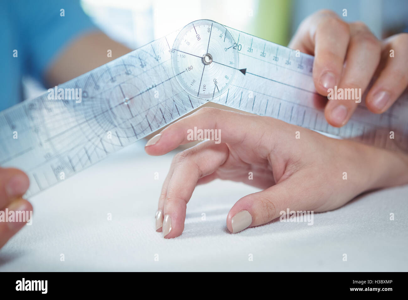 Physiotherapist examining female patient's finger with goniometer Stock ...