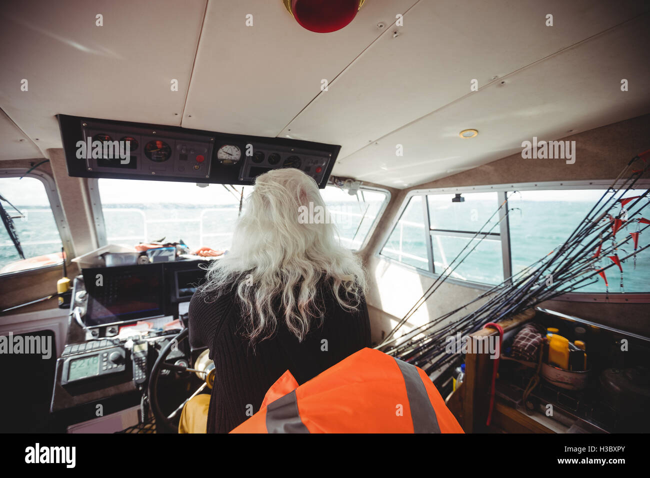 Fisherman driving fishing boat Stock Photo - Alamy