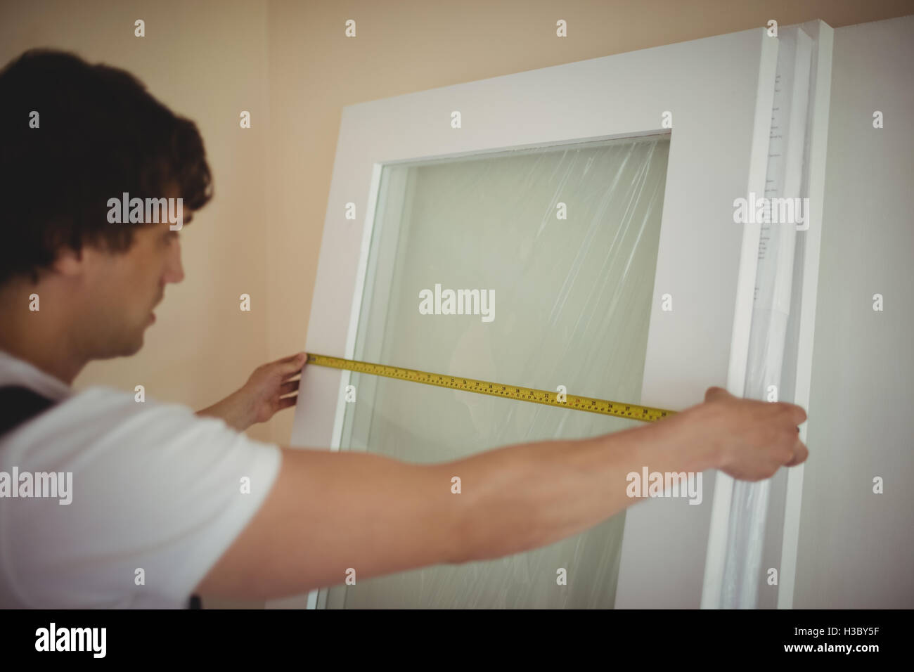 Carpenter measuring a door Stock Photo - Alamy