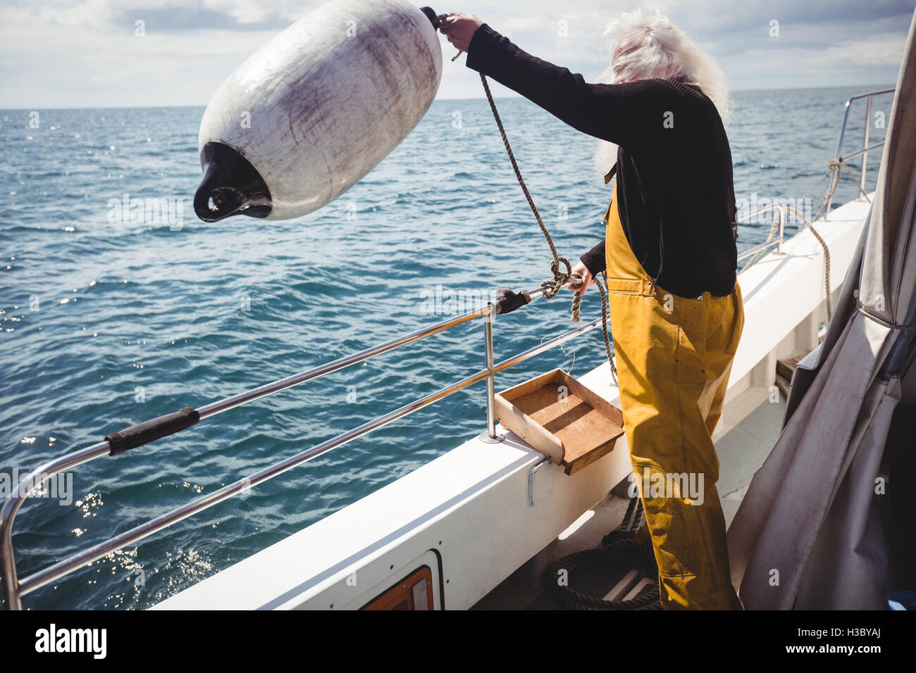 Fisherman throwing a buoy into the sea Stock Photo - Alamy