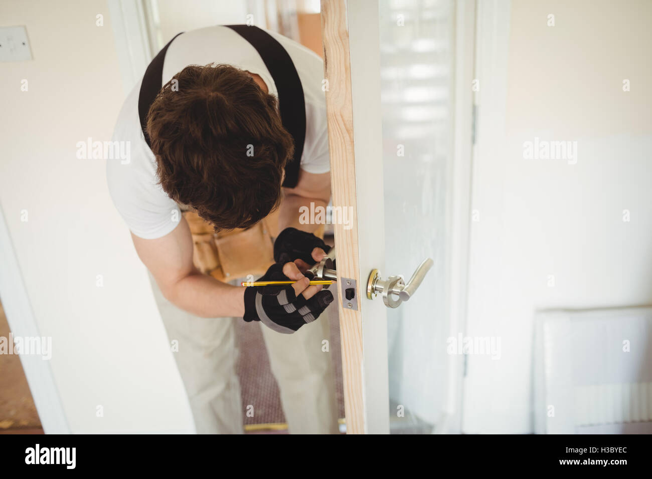 Carpenter fixing door lock Stock Photo - Alamy