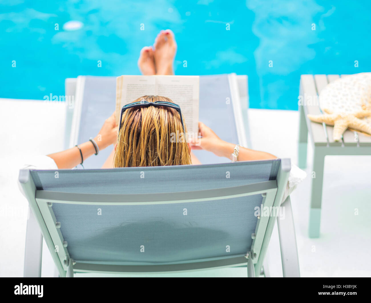 Resort pool deckchair book hi-res stock photography and images - Alamy