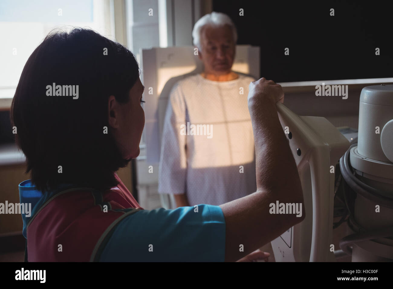 Female doctor sets up the machine to x-ray a patients chest Stock Photo ...