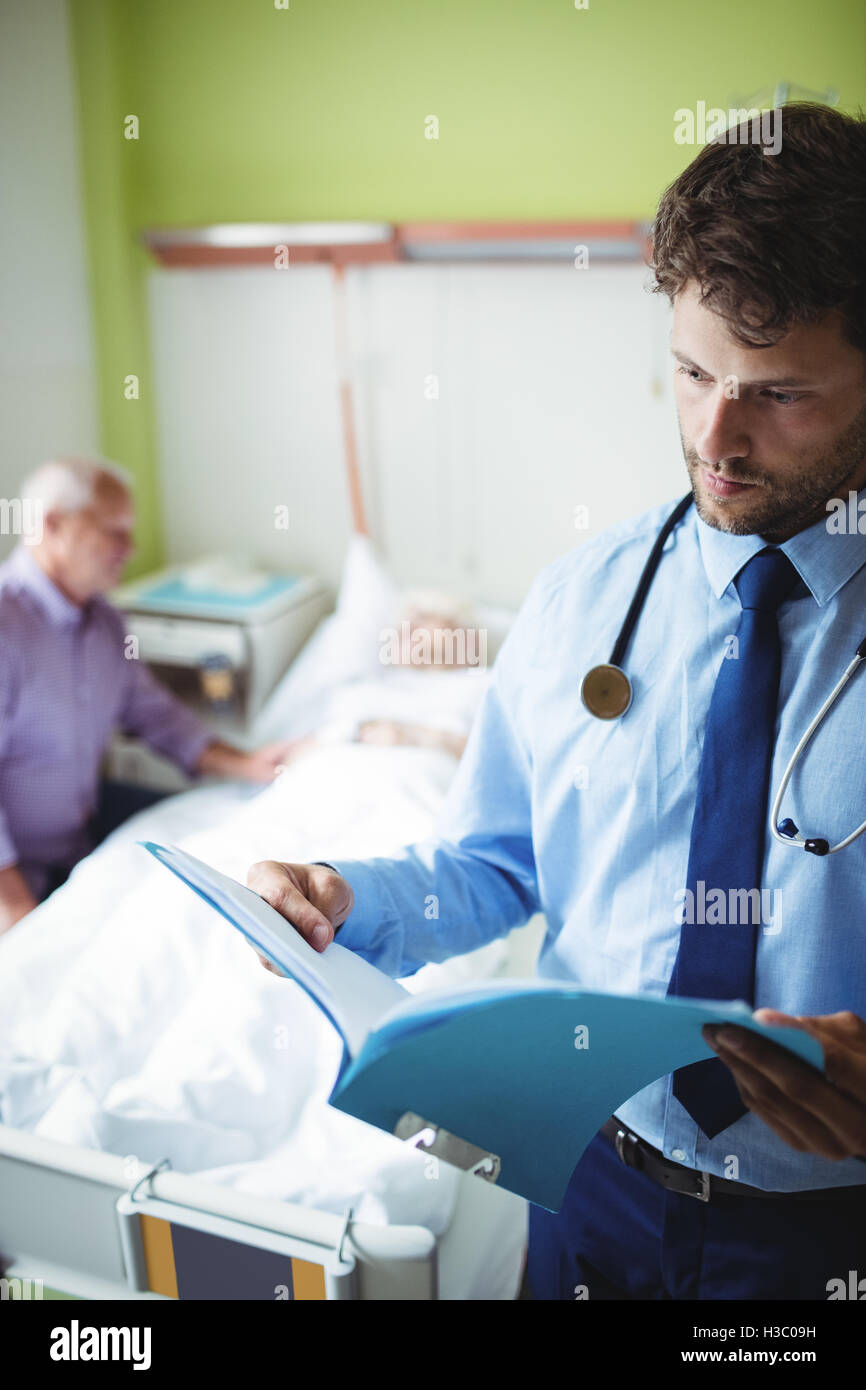 Doctor checking a report Stock Photo - Alamy