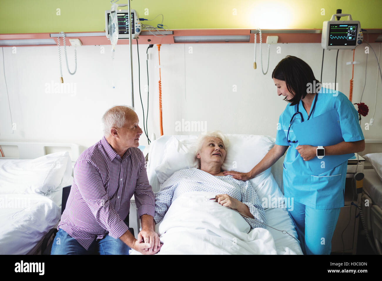 Senior couple interacting with nurse Stock Photo - Alamy