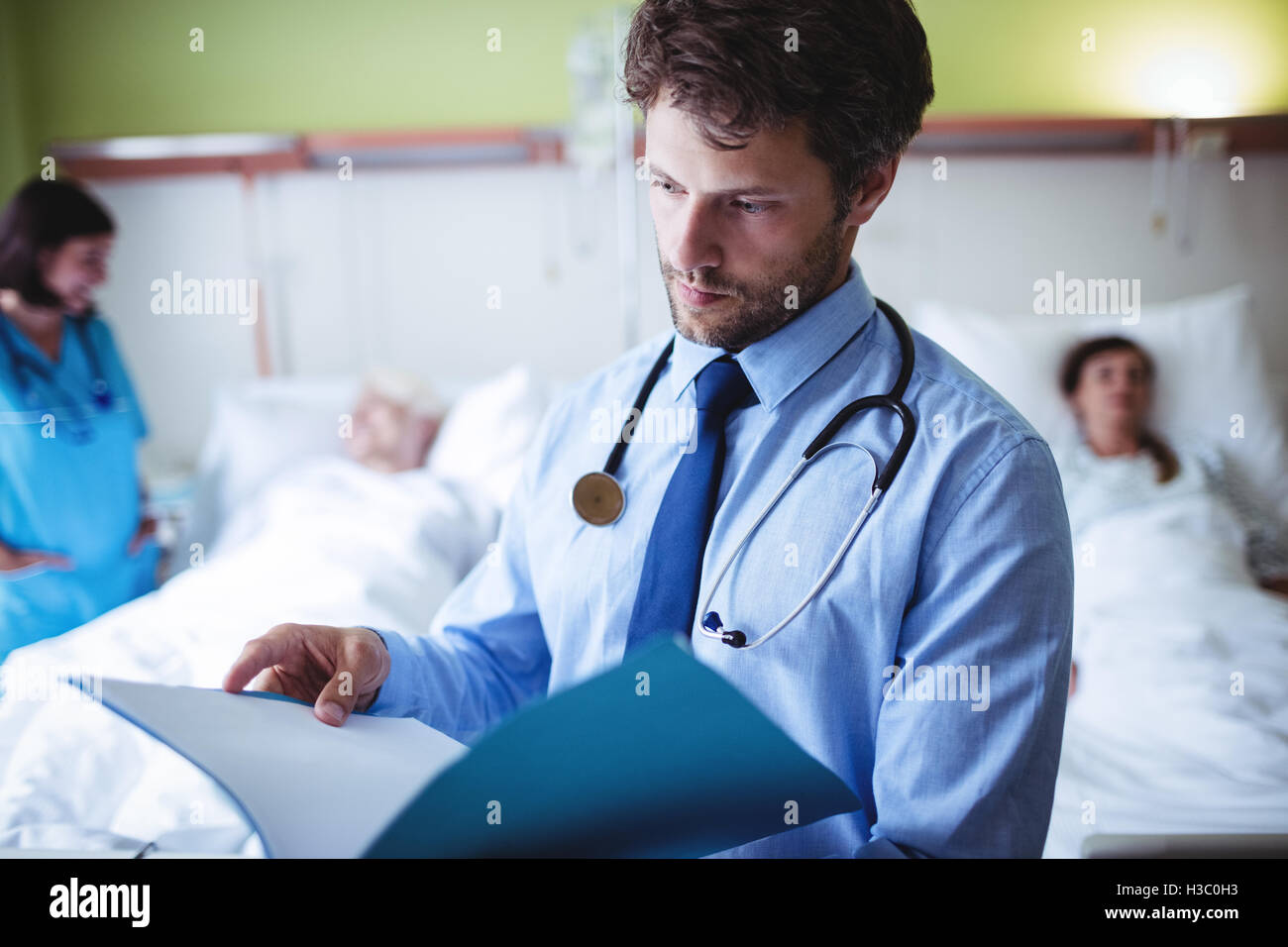 Doctor checking report Stock Photo - Alamy
