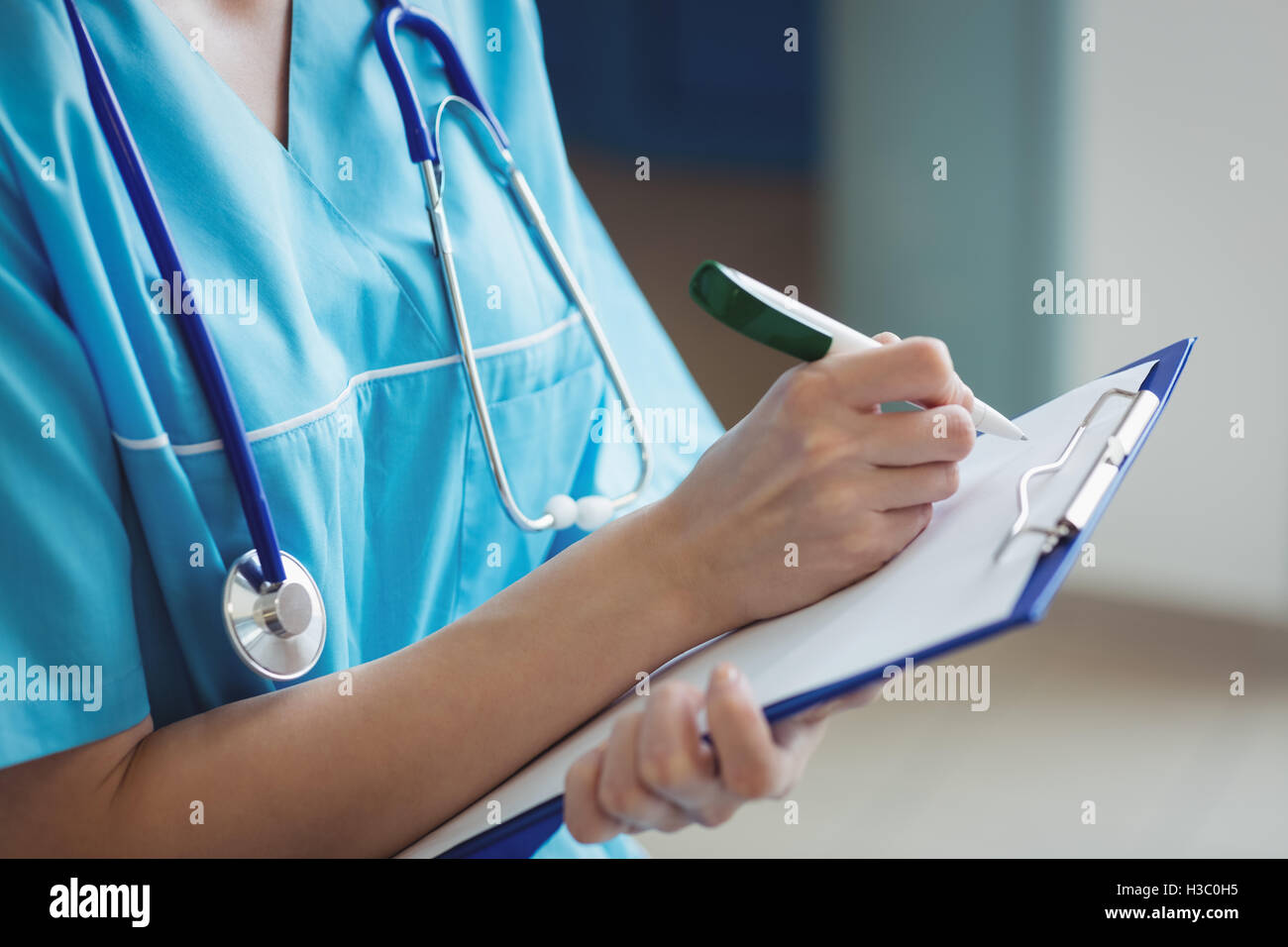 Mid section of nurse writing on clipboard Stock Photo - Alamy