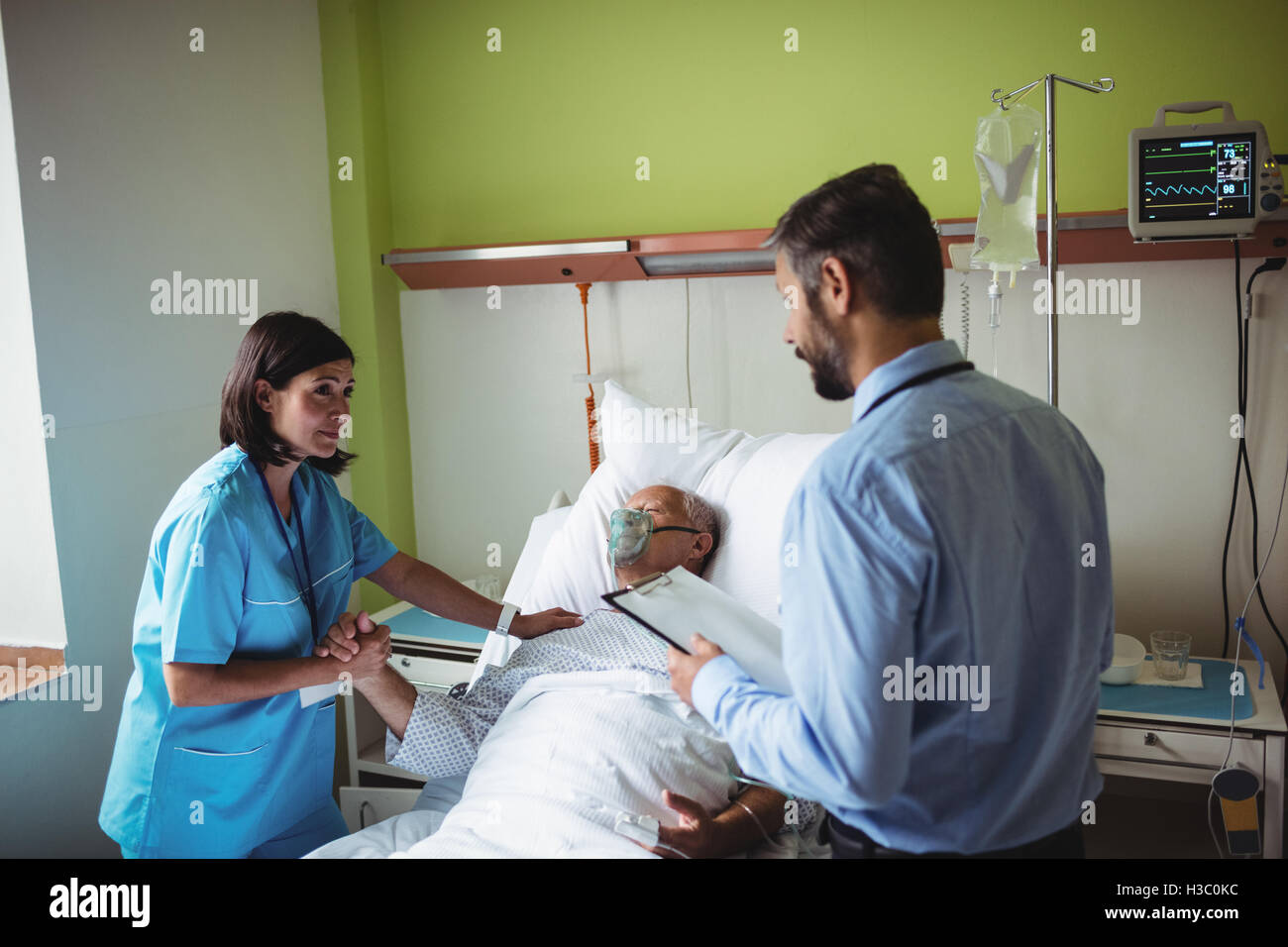 Nurse consoling senior patient with doctor Stock Photo - Alamy
