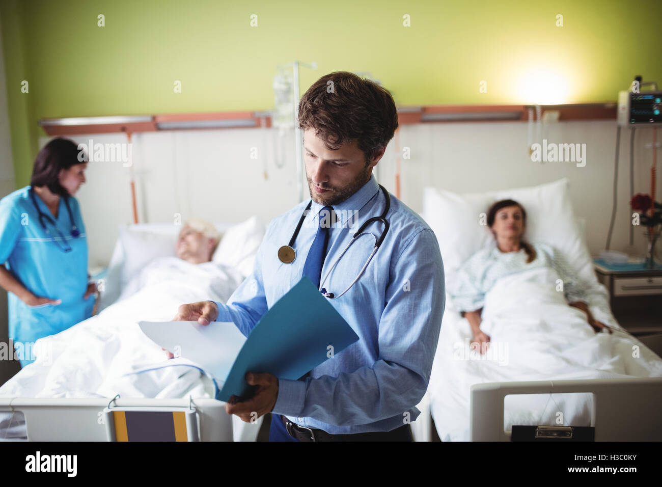 Doctor checking report Stock Photo - Alamy