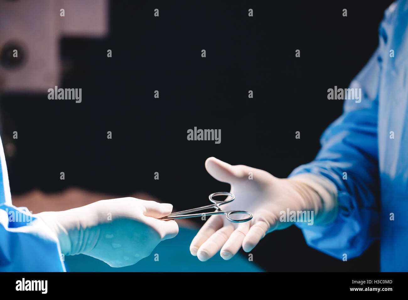 Surgeons giving operation scissor to colleague in operation room Stock ...