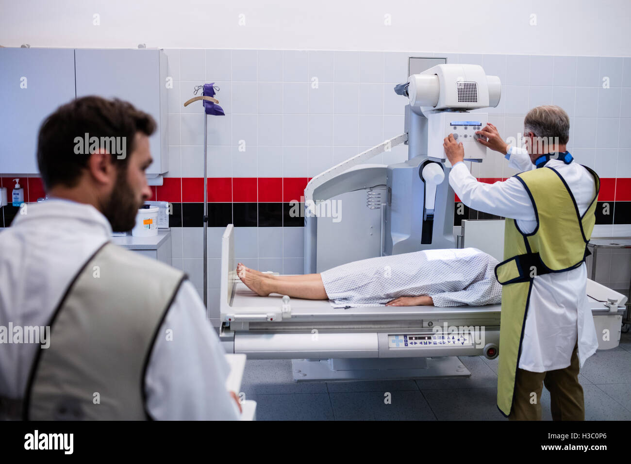 Doctor using x-ray machine to examine patient Stock Photo - Alamy