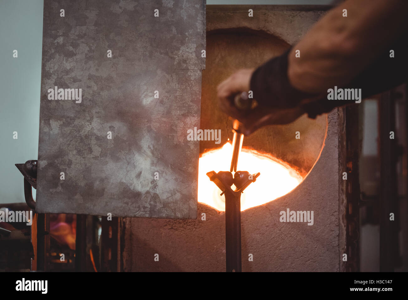 Glassblower heating a glass in furnace Stock Photo - Alamy