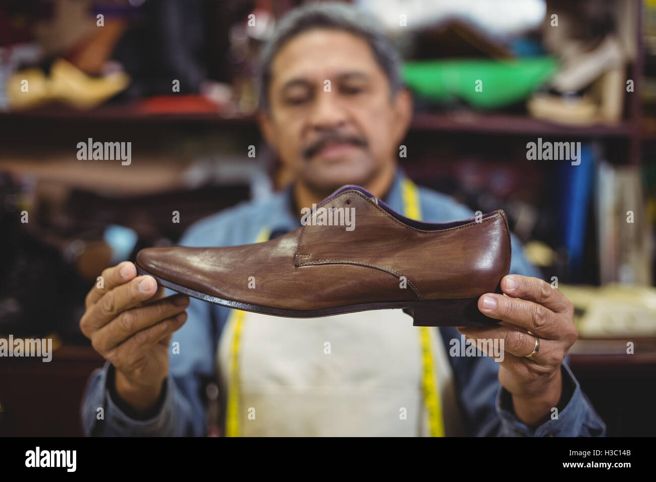 Shoemaker examining a shoe Stock Photo - Alamy