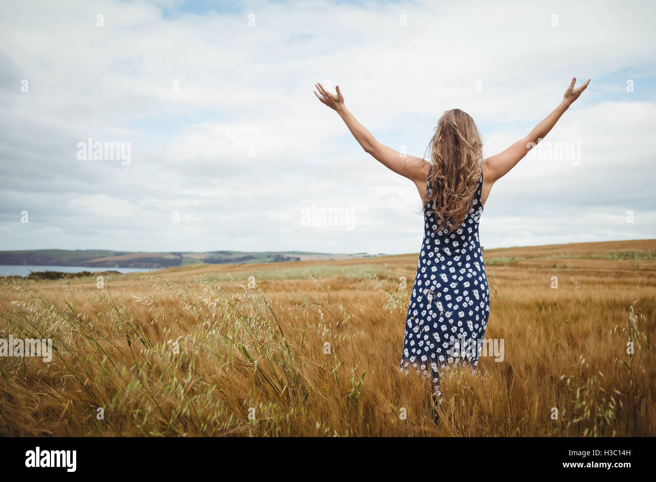 Rear view woman standing with arms outstretched Stock Photo - Alamy