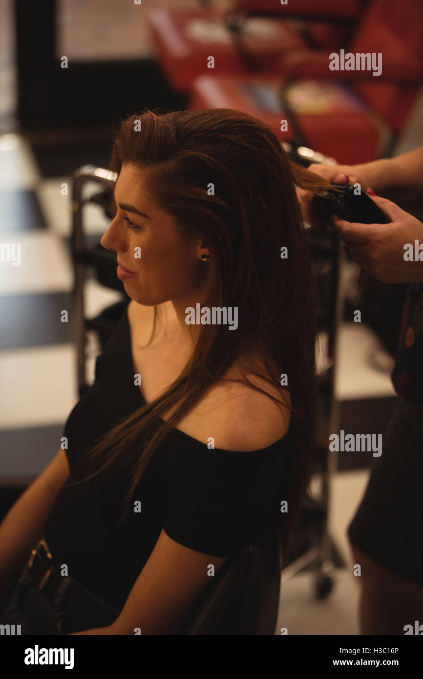 Pretty young woman straightening hair hi-res stock photography and ...