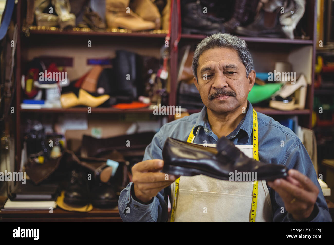 Shoemaker examining a shoe Stock Photo - Alamy