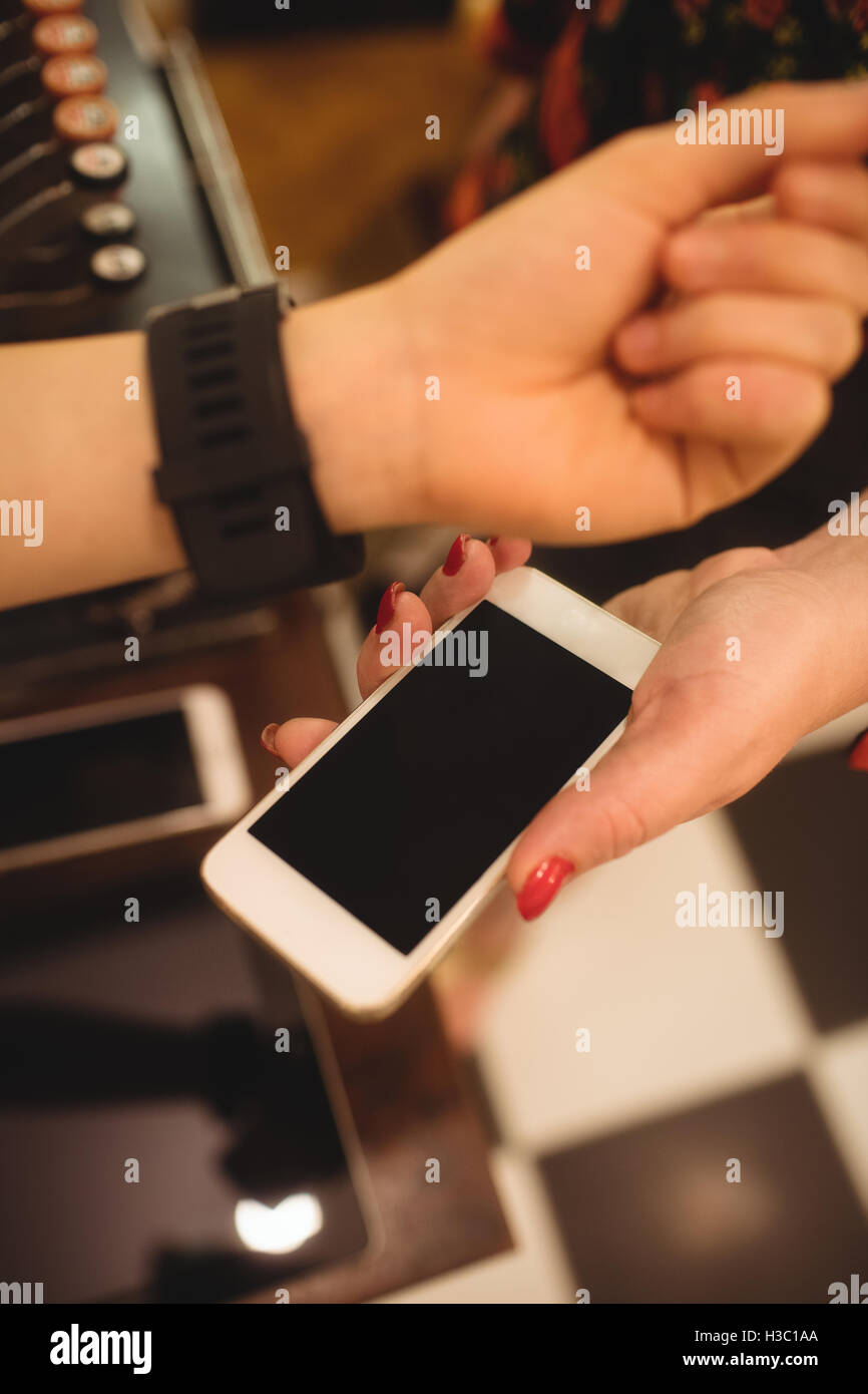 Hand making payment through smartwatch Stock Photo - Alamy