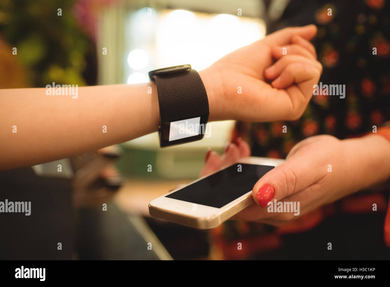 Hand making payment through smartwatch Stock Photo - Alamy