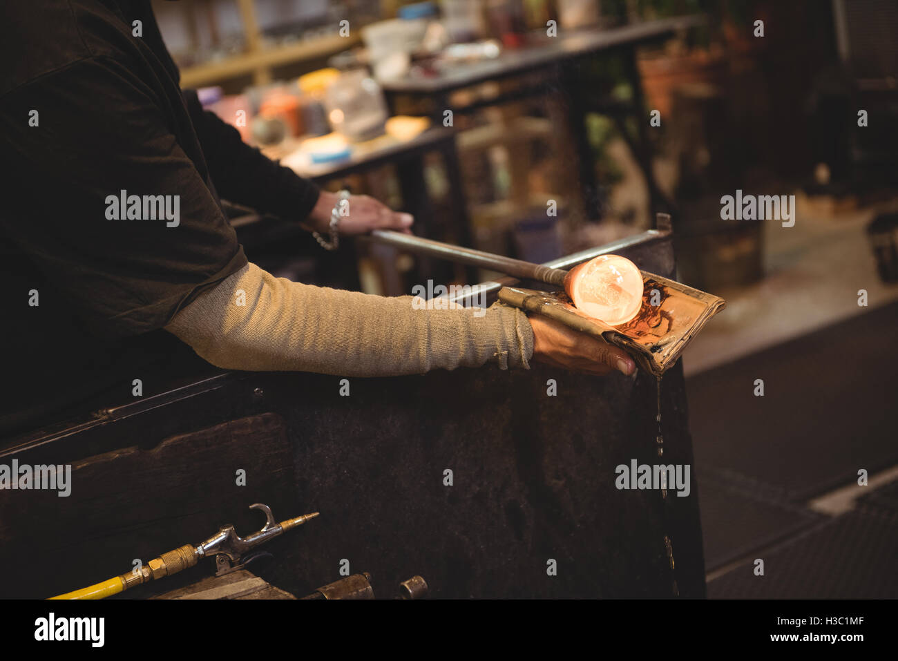 Glassblower shaping a blown glass piece with a wet cloth Stock Photo ...