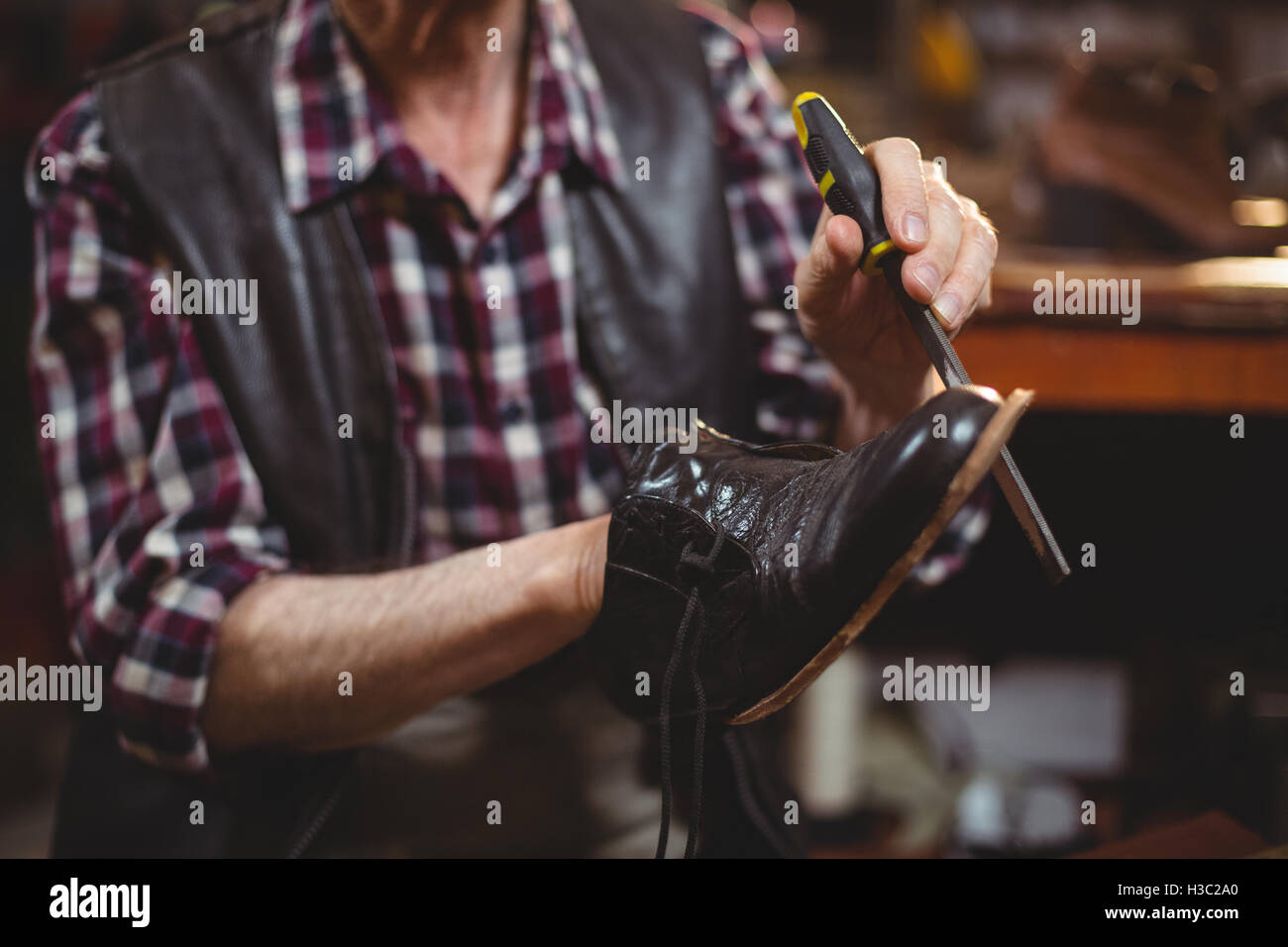 Shoemaker repairing a shoe Stock Photo - Alamy