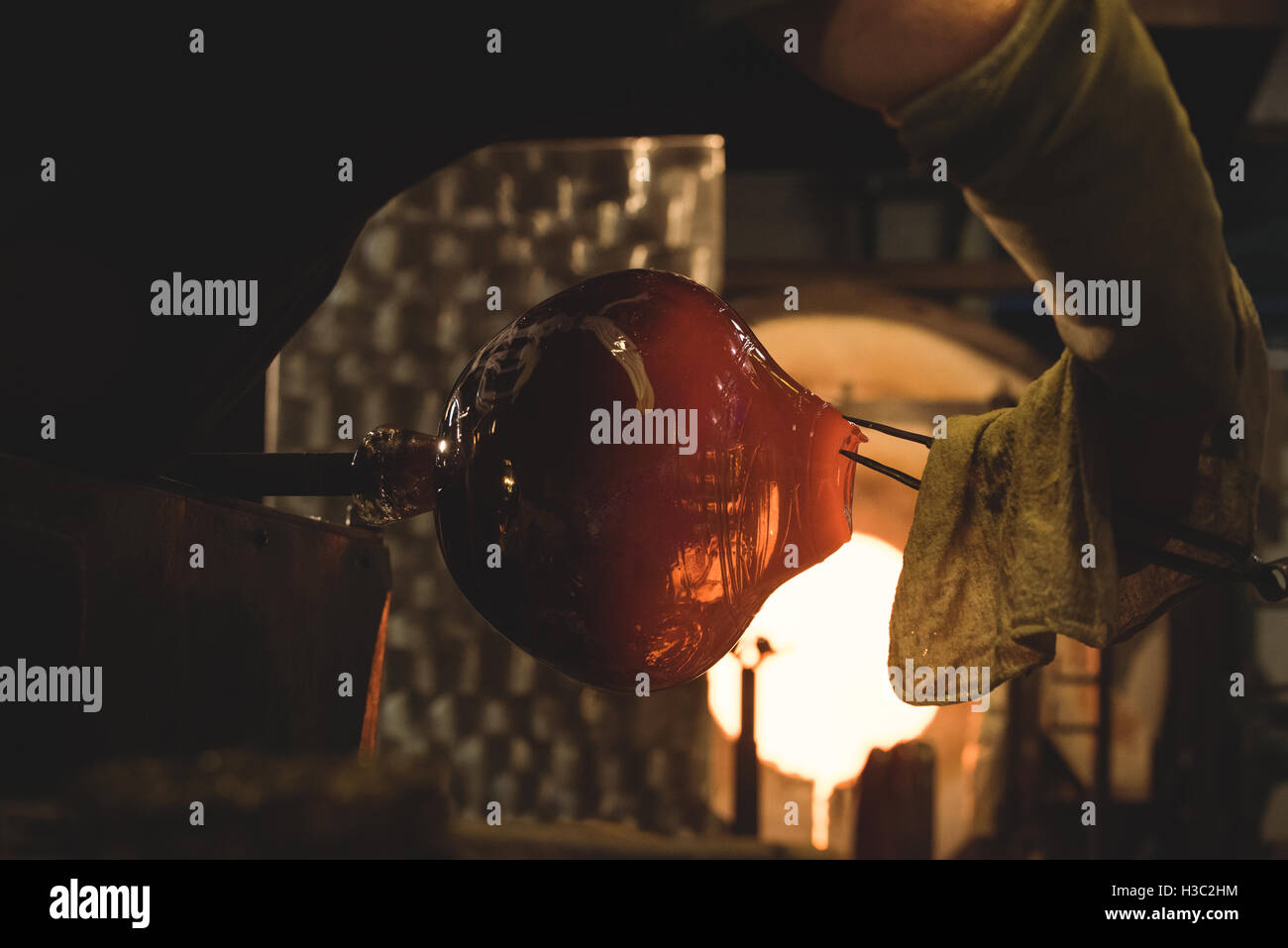 Glassblower heating piece of glass in furnace Stock Photo - Alamy