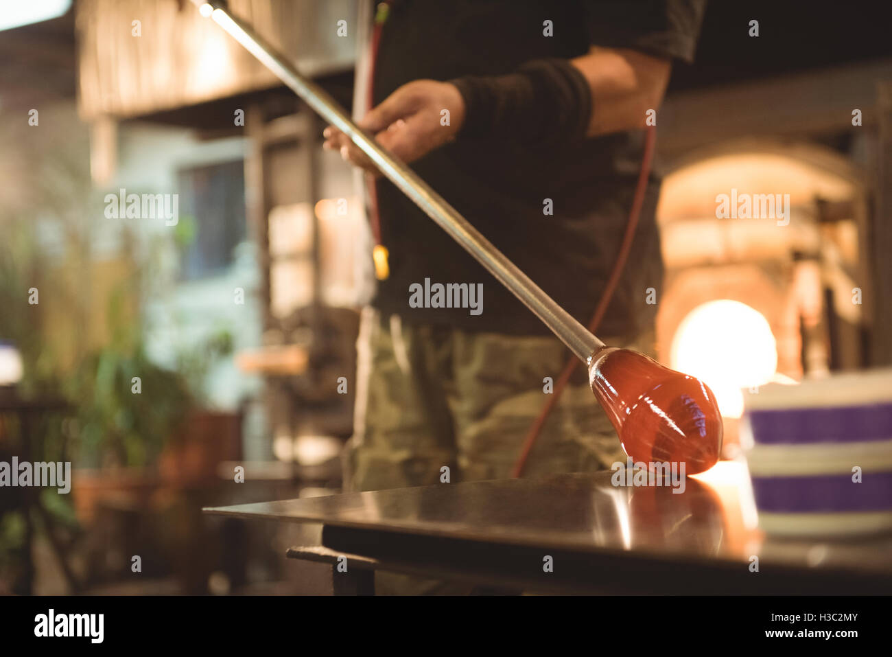 Glassblower shaping a molten glass Stock Photo - Alamy