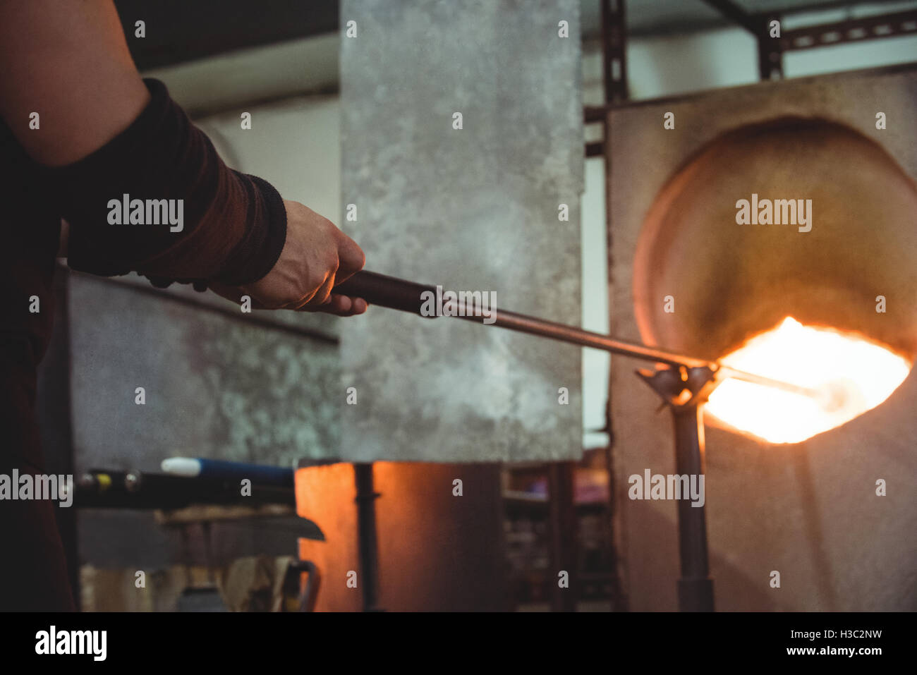 Glassblower heating a glass in furnace Stock Photo - Alamy