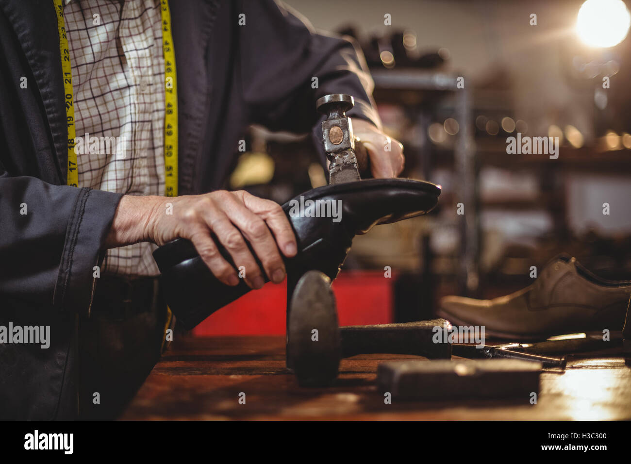 Shoemaker hammering on a shoe Stock Photo - Alamy
