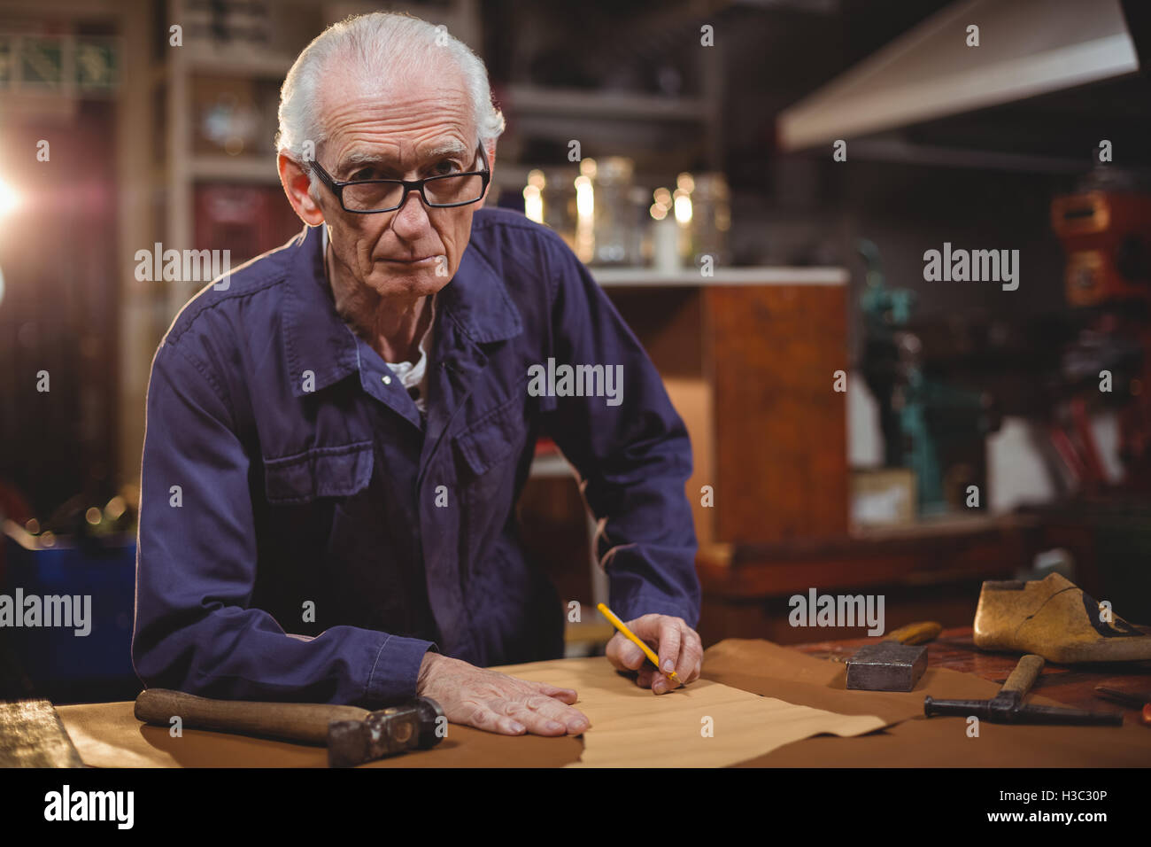 Portrait of shoemaker cutting a piece of leather Stock Photo - Alamy