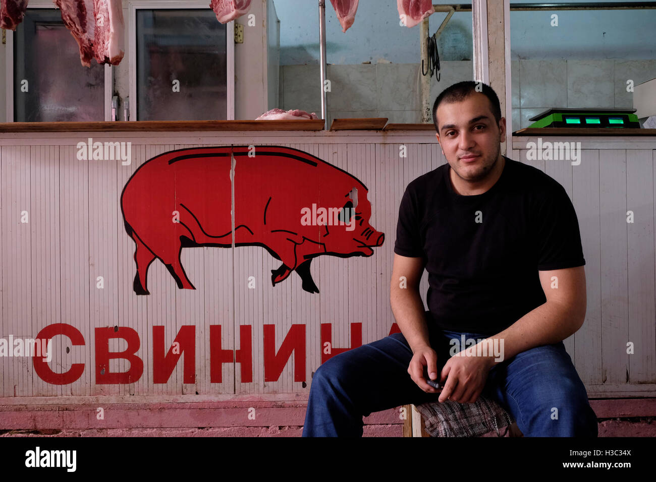 A vendor selling pork meat in Taza Bazaar market in the city of Baku in ...