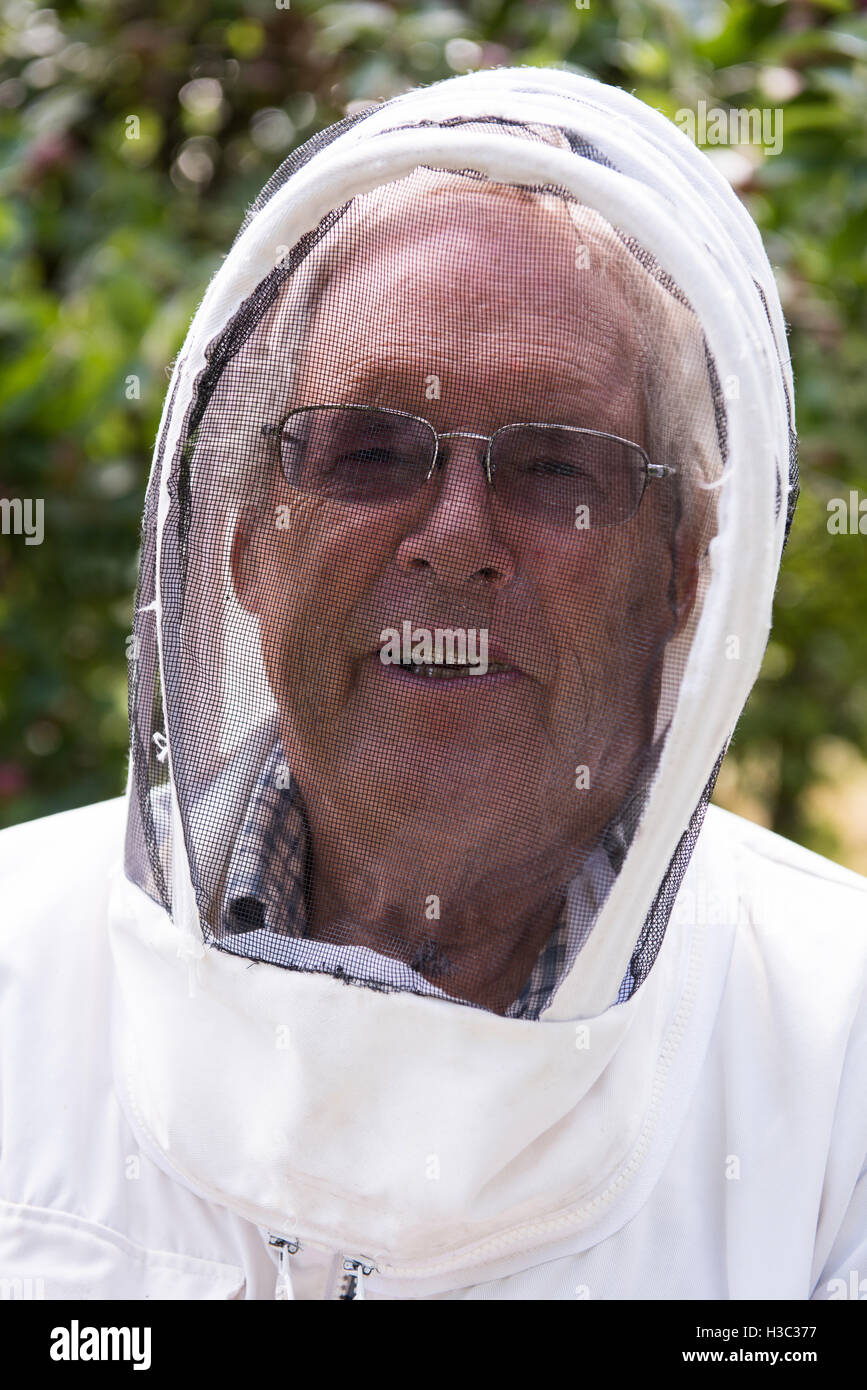 Beekeeper standing with arms crossed Stock Photo - Alamy