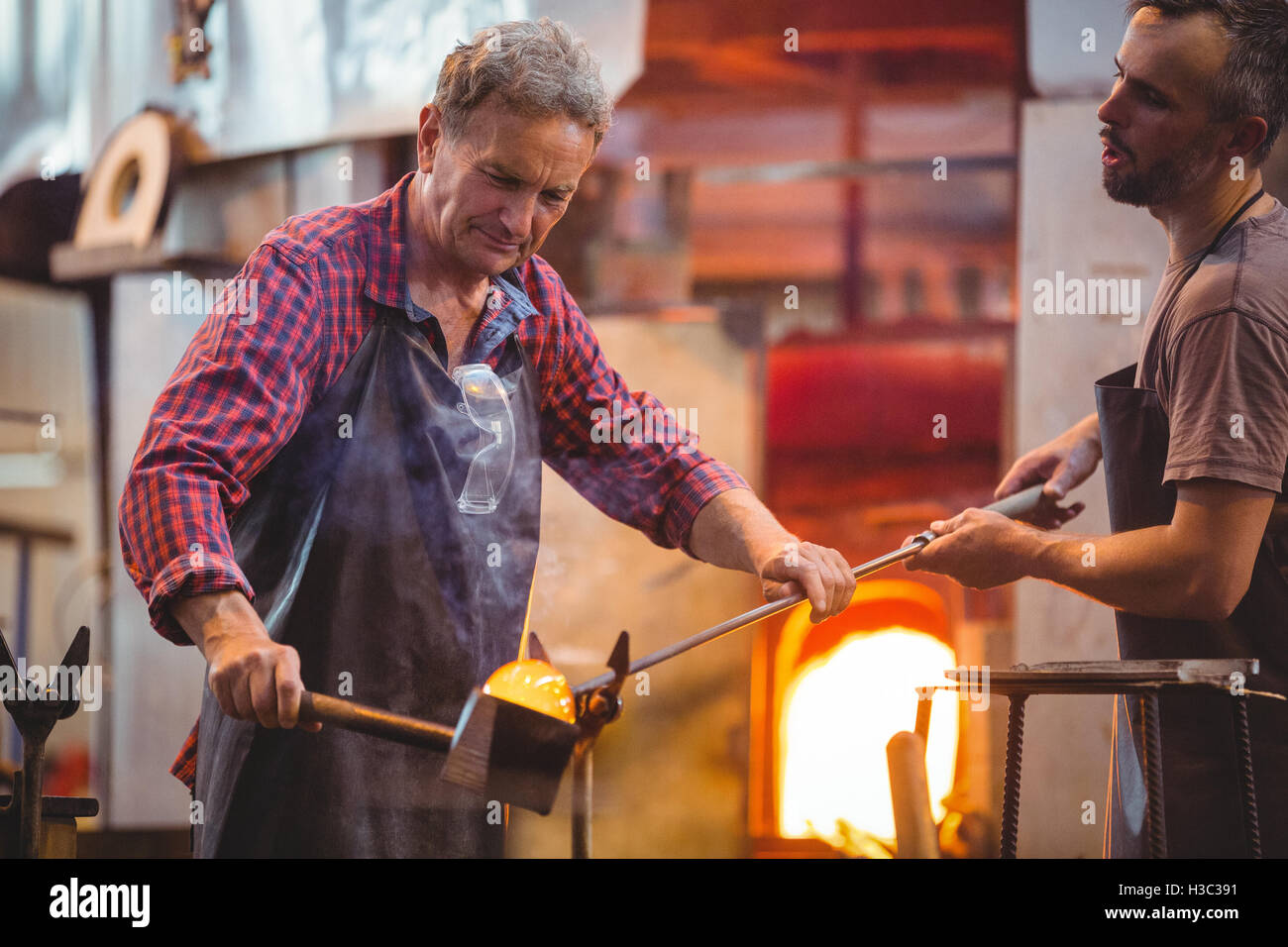 Glassblower forming and shaping a molten glass Stock Photo - Alamy