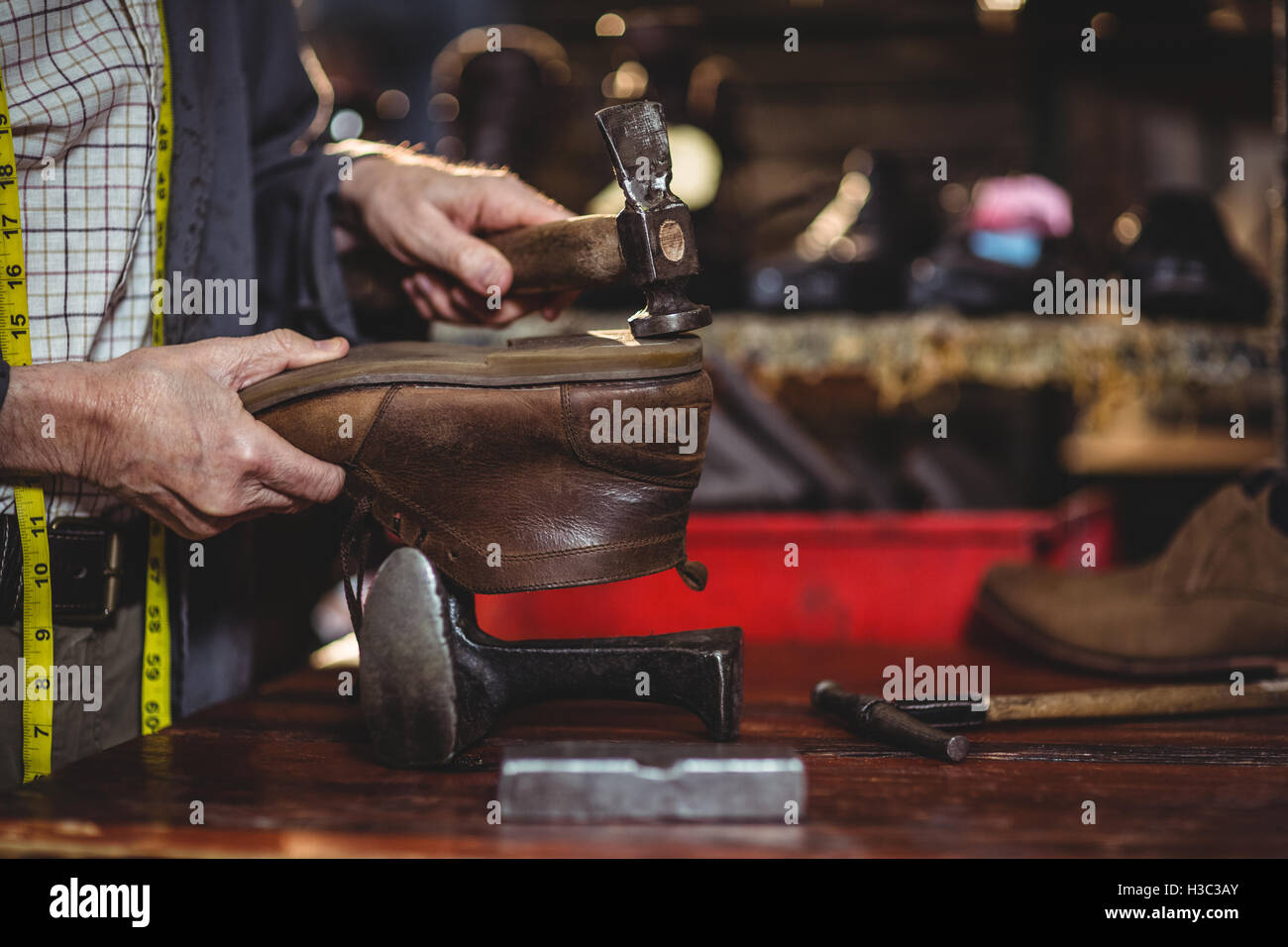 Shoemaker hammering on a shoe Stock Photo - Alamy