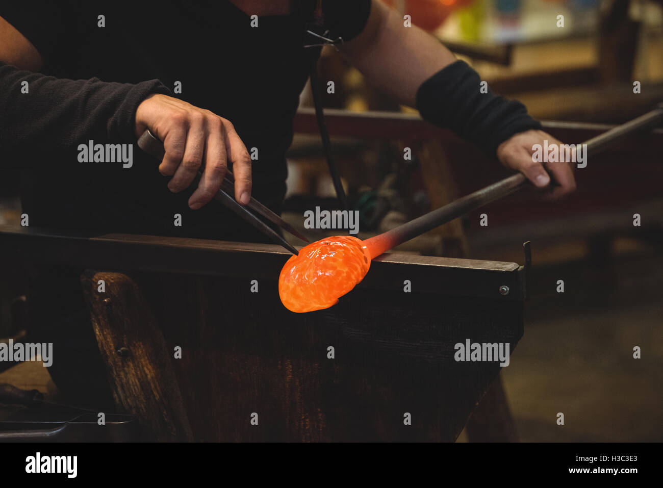 Glassblower shaping a molten glass Stock Photo - Alamy