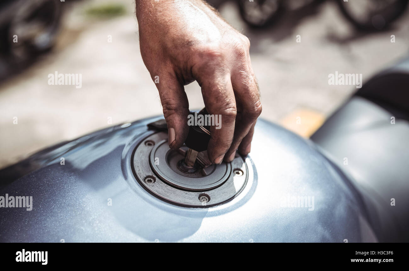 Mechanic closing a fuel tank of motor bike Stock Photo - Alamy