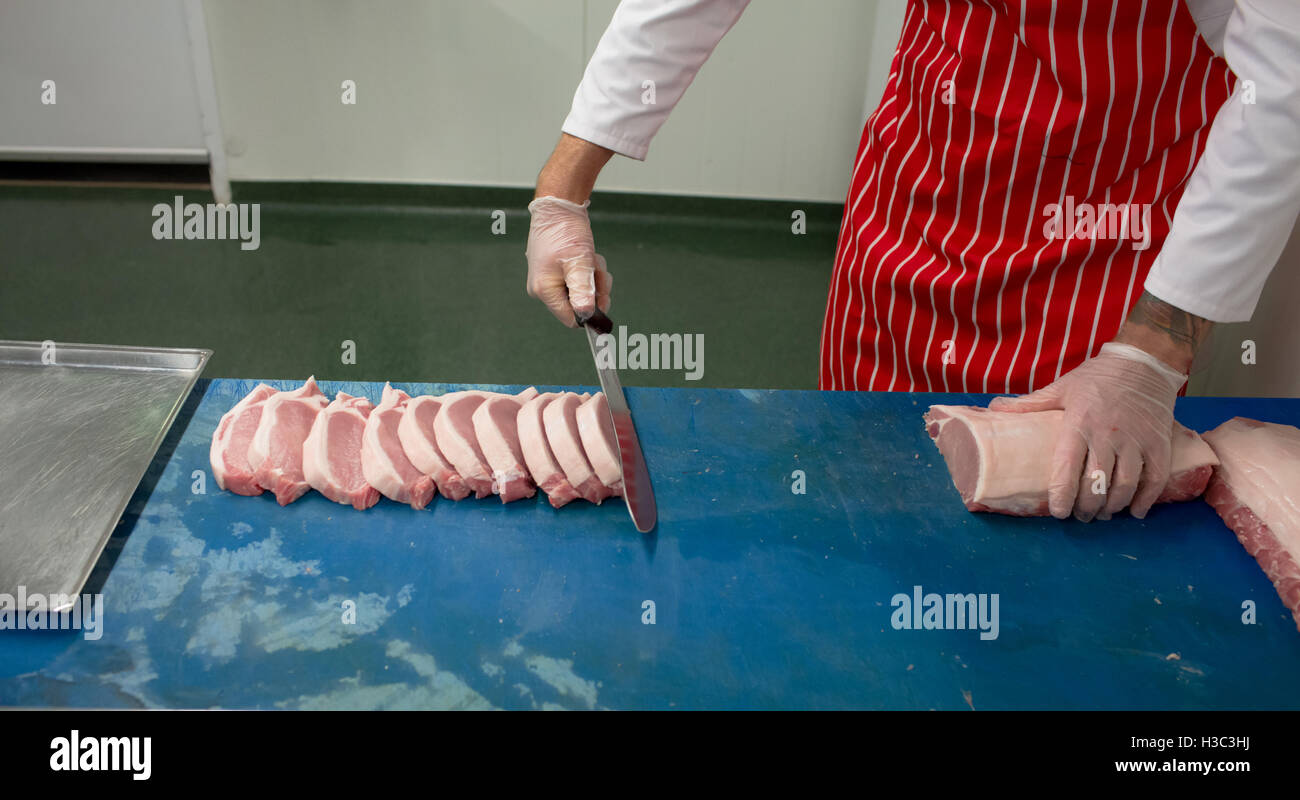 Mid section of butcher slicing meat Stock Photo - Alamy