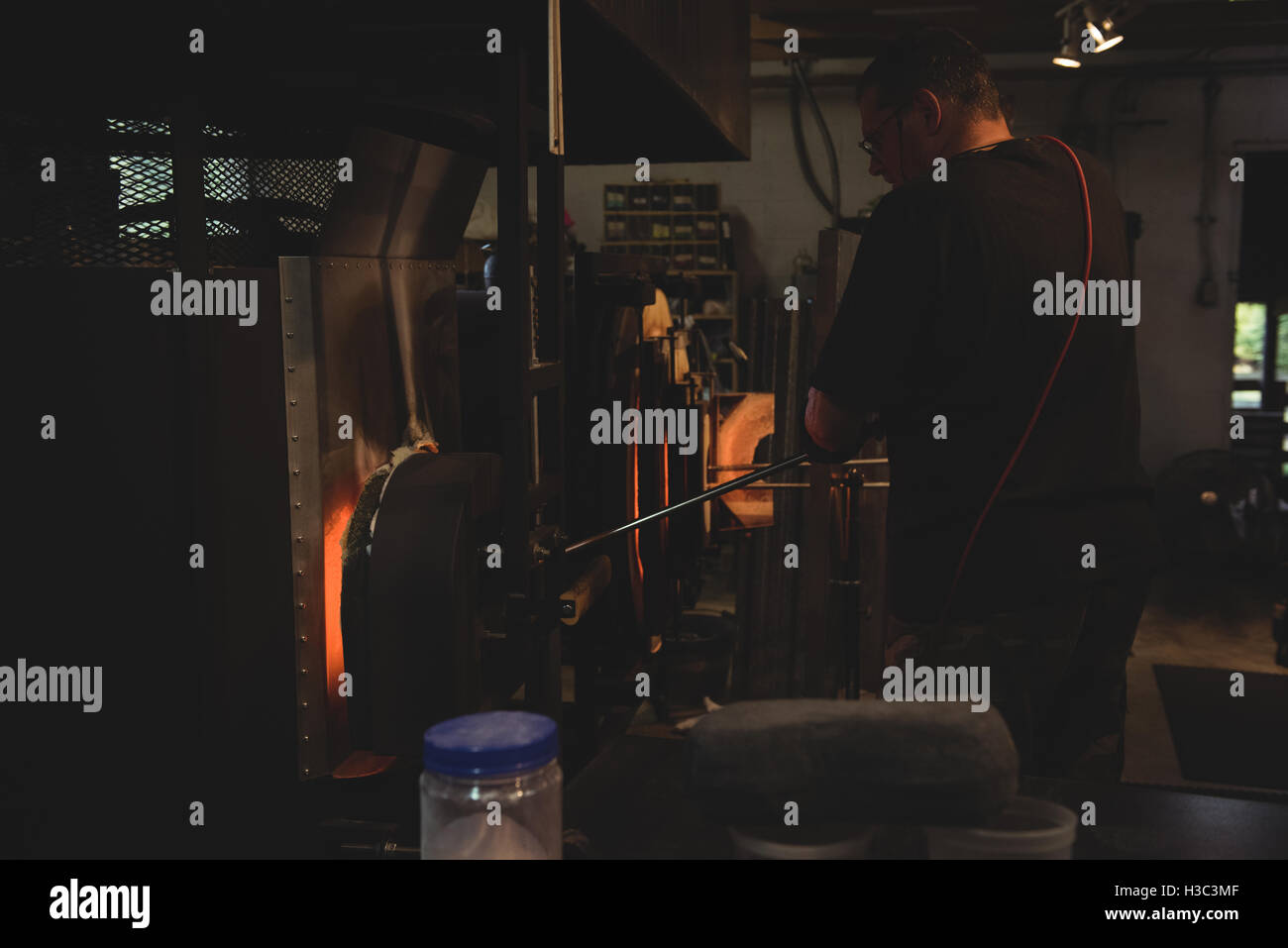 Glassblower heating a glass in furnace Stock Photo - Alamy